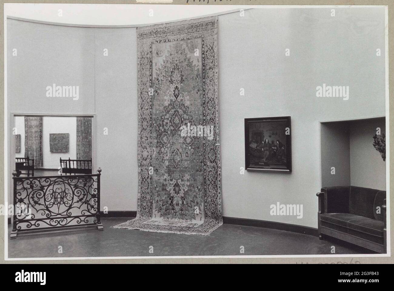 Corner of a hall with carpet, painting, sofa and cast iron fence ...