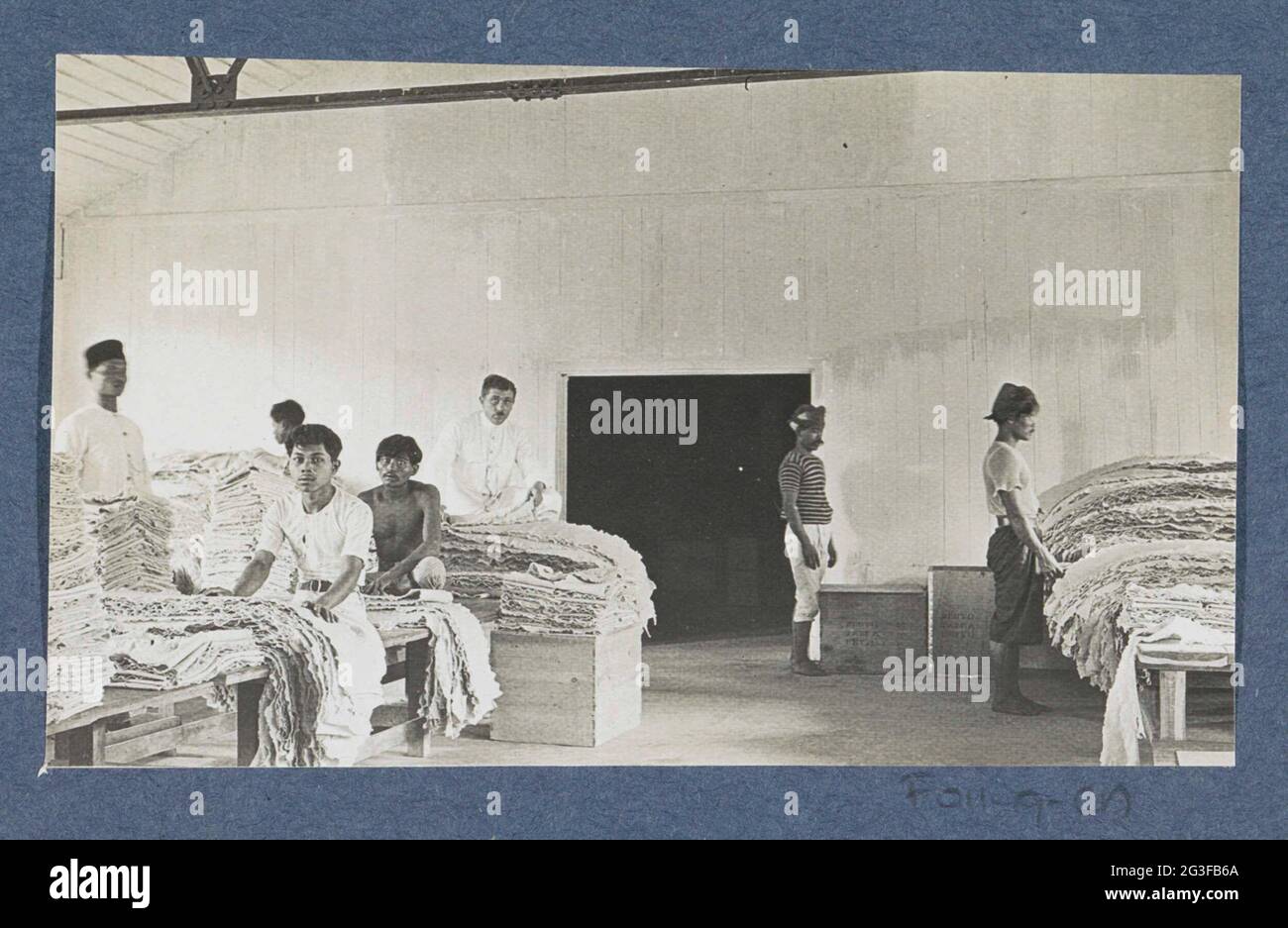 Indian workers sort rubber in a shed on Sumatra. Part of travel album ...