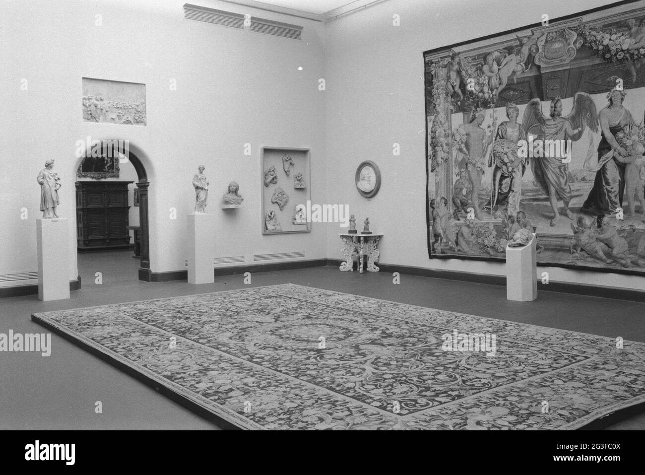 Room with images, display case, floor and tapestry; Interiors West ...