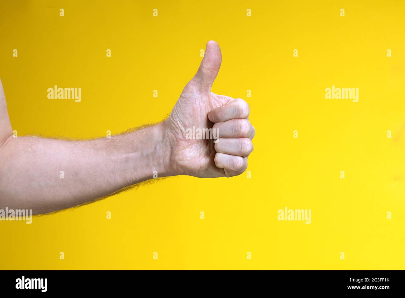 Man's hand with thumb up isolated on yellow background. Showing like ...