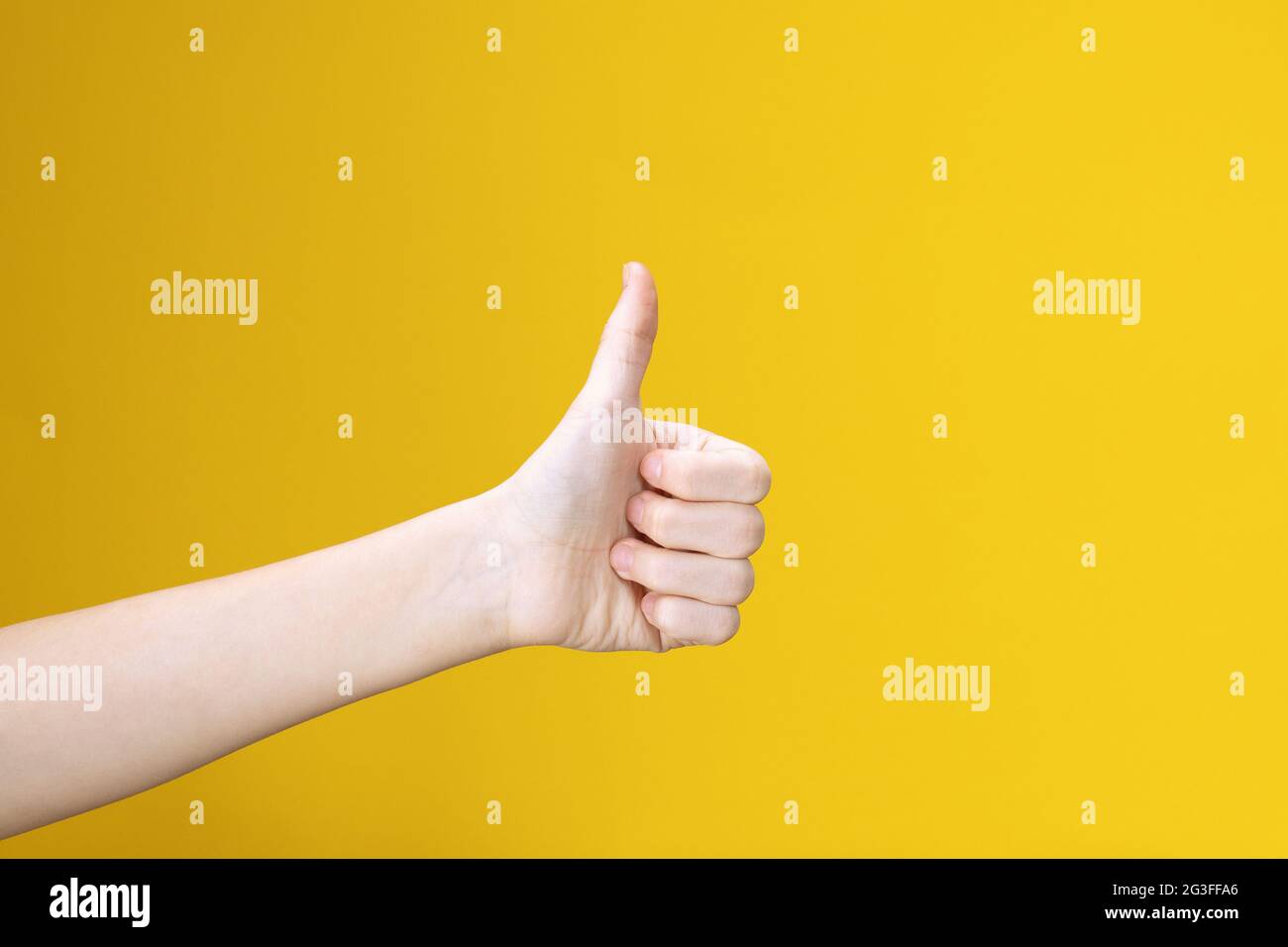 Teens hand with thumb up isolated on yellow background. Showing like ...