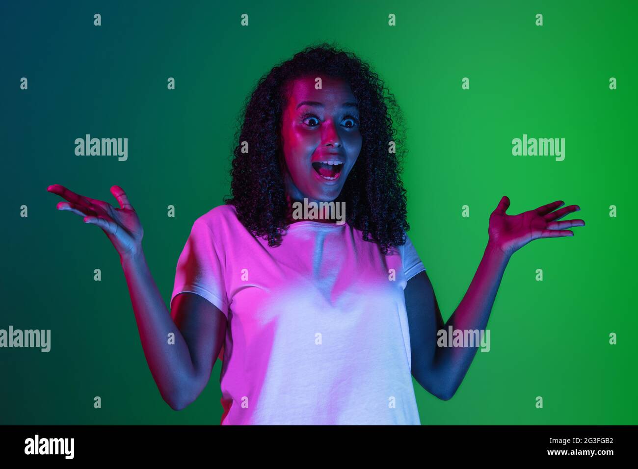 Young woman's portrait on gradient colors studio background in neon ...