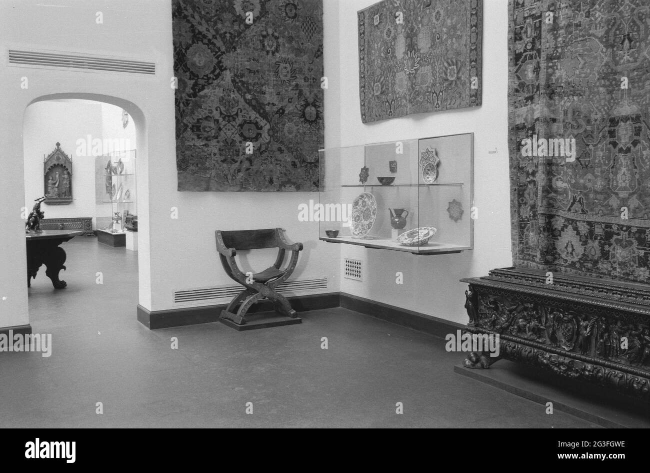 Room with tapestries, display case, chair and passage; Interiors West ...