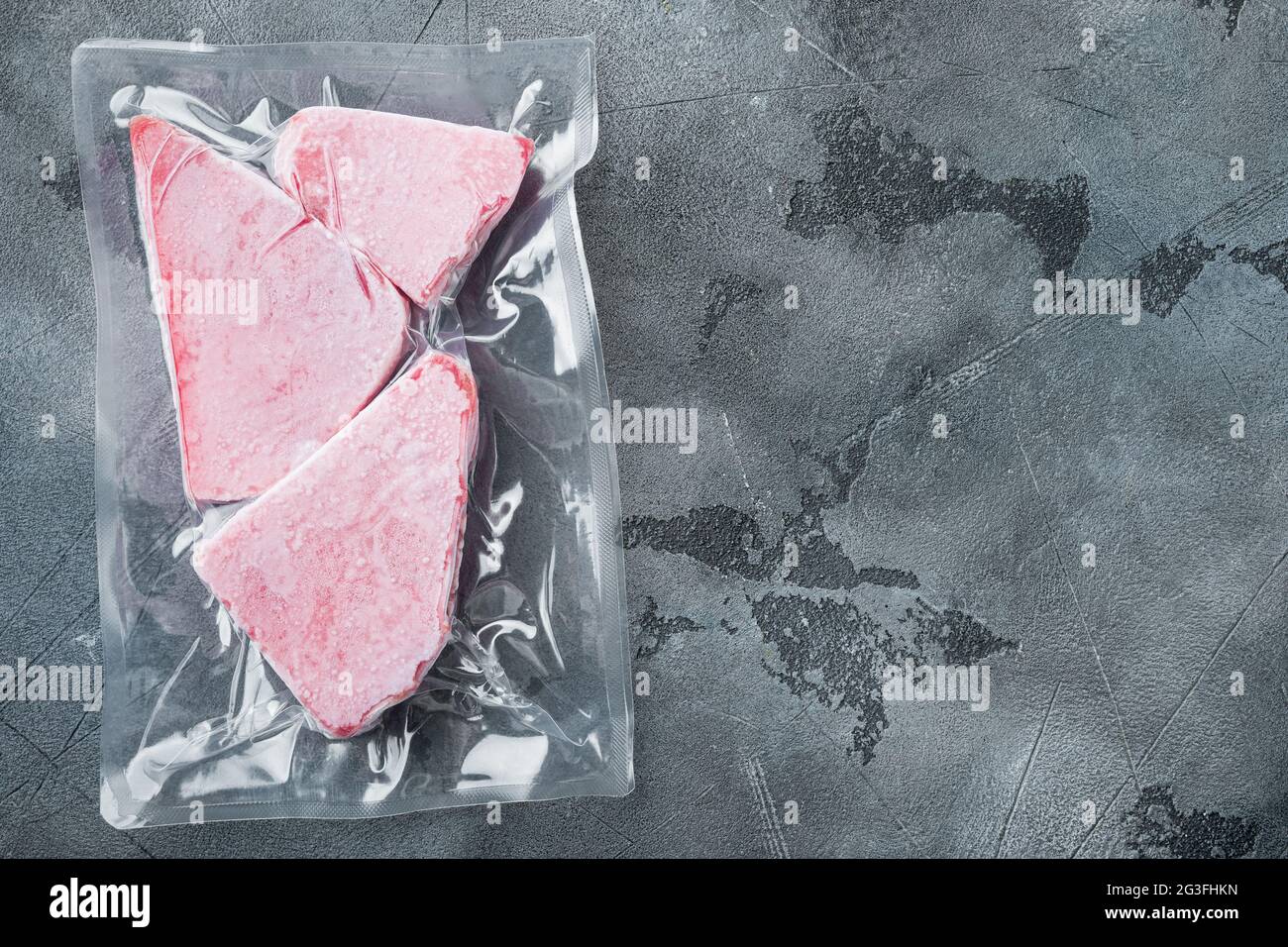 Raw frozen tuna fillet in vacuum packaging set, on gray stone ...