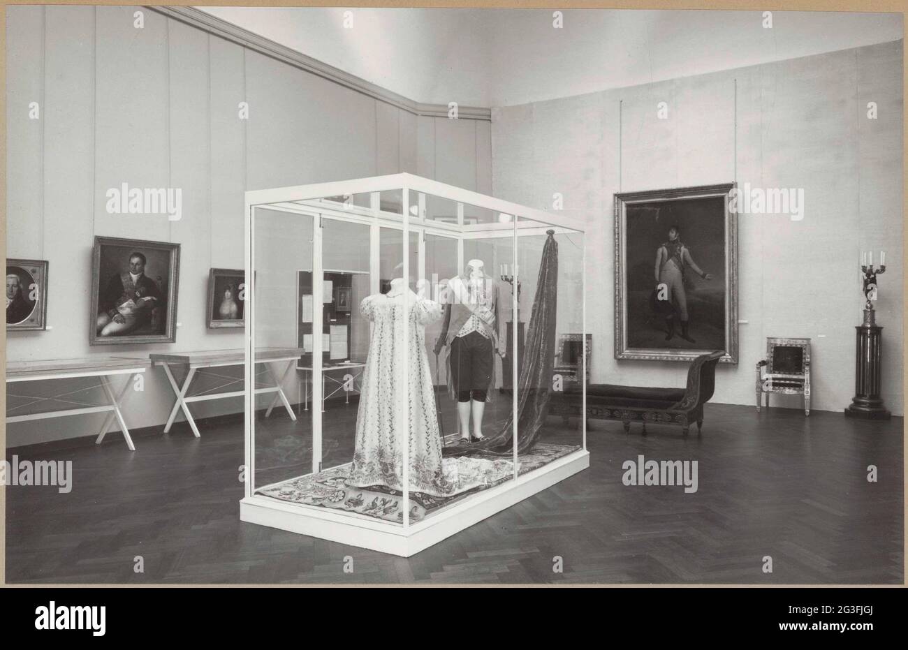 Room with portraits, showcases and a large display with two costumes in ...
