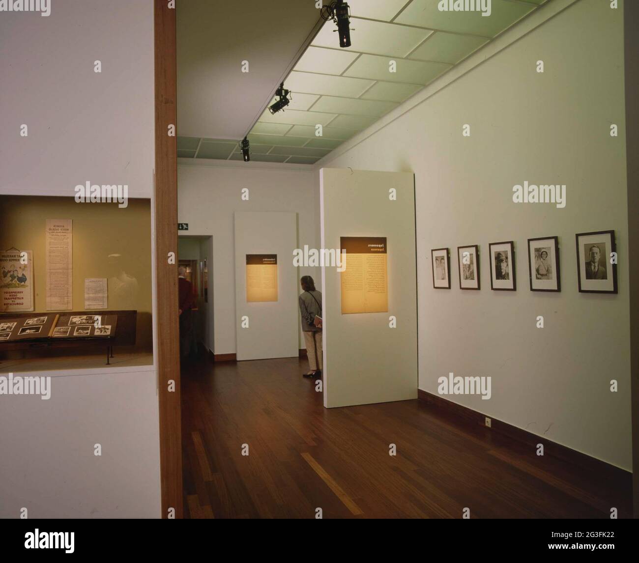 Corner of a room including photos (portraits) and information boards ...
