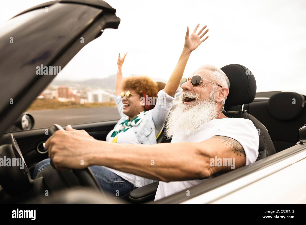Happy senior couple having fun in convertible car during summer ...
