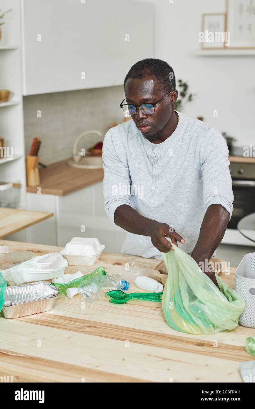 African young man sorting the rubbish in the kitchen Stock Photo - Alamy