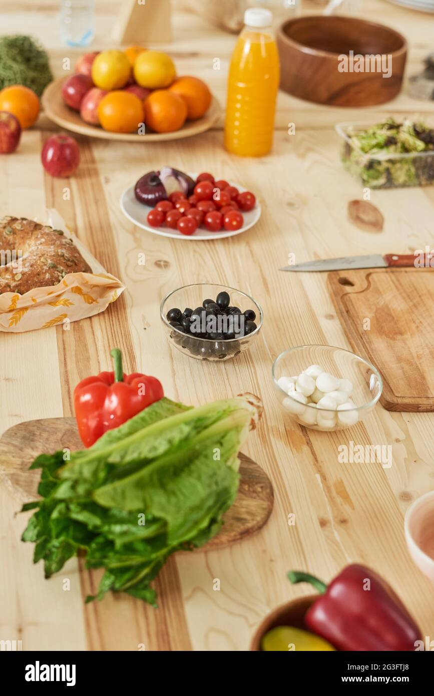 Close-up of fresh fruits and vegetables on the wooden kitchen table ...