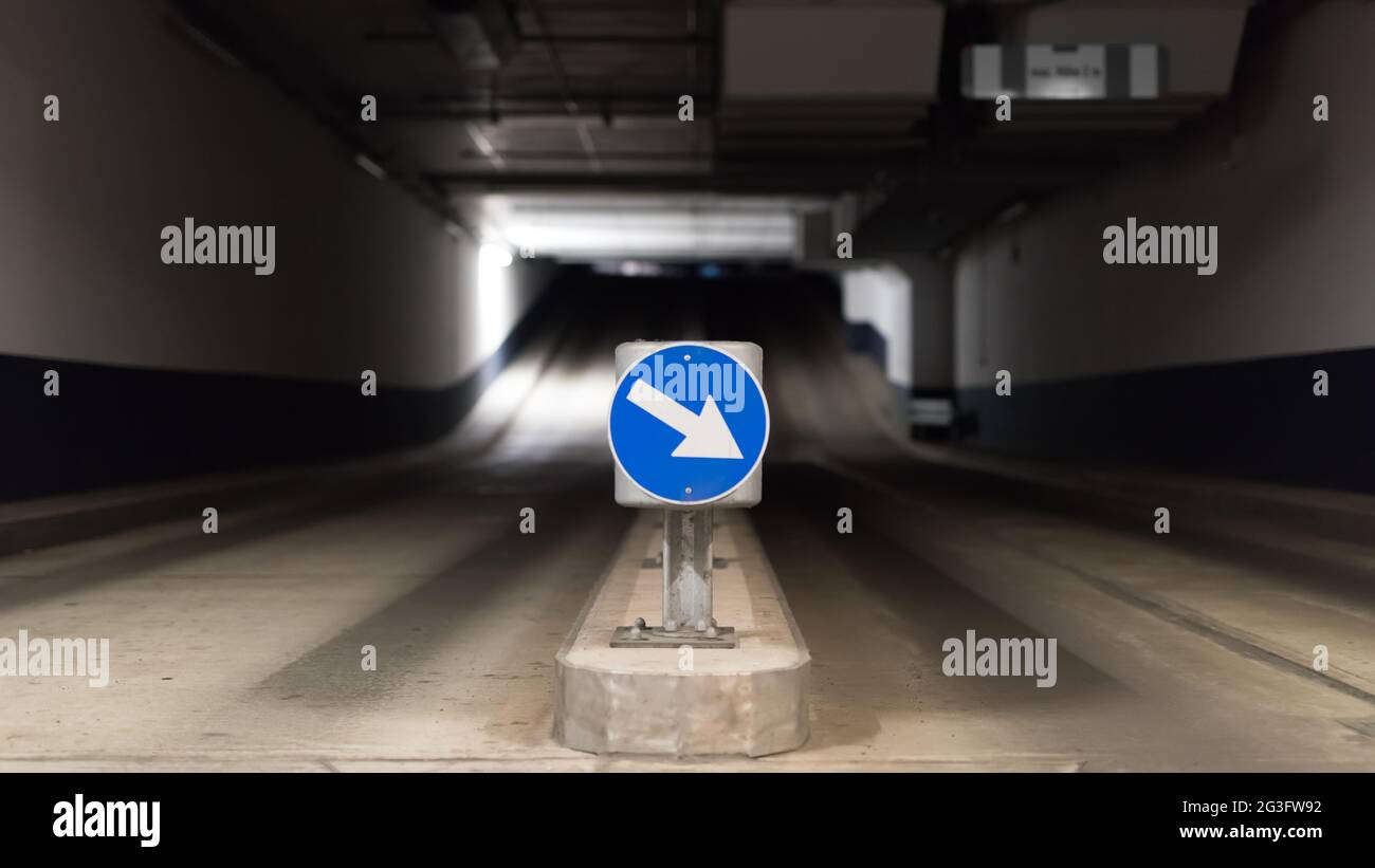 Blue traffic sign with directional arrow and two lanes Stock Photo - Alamy