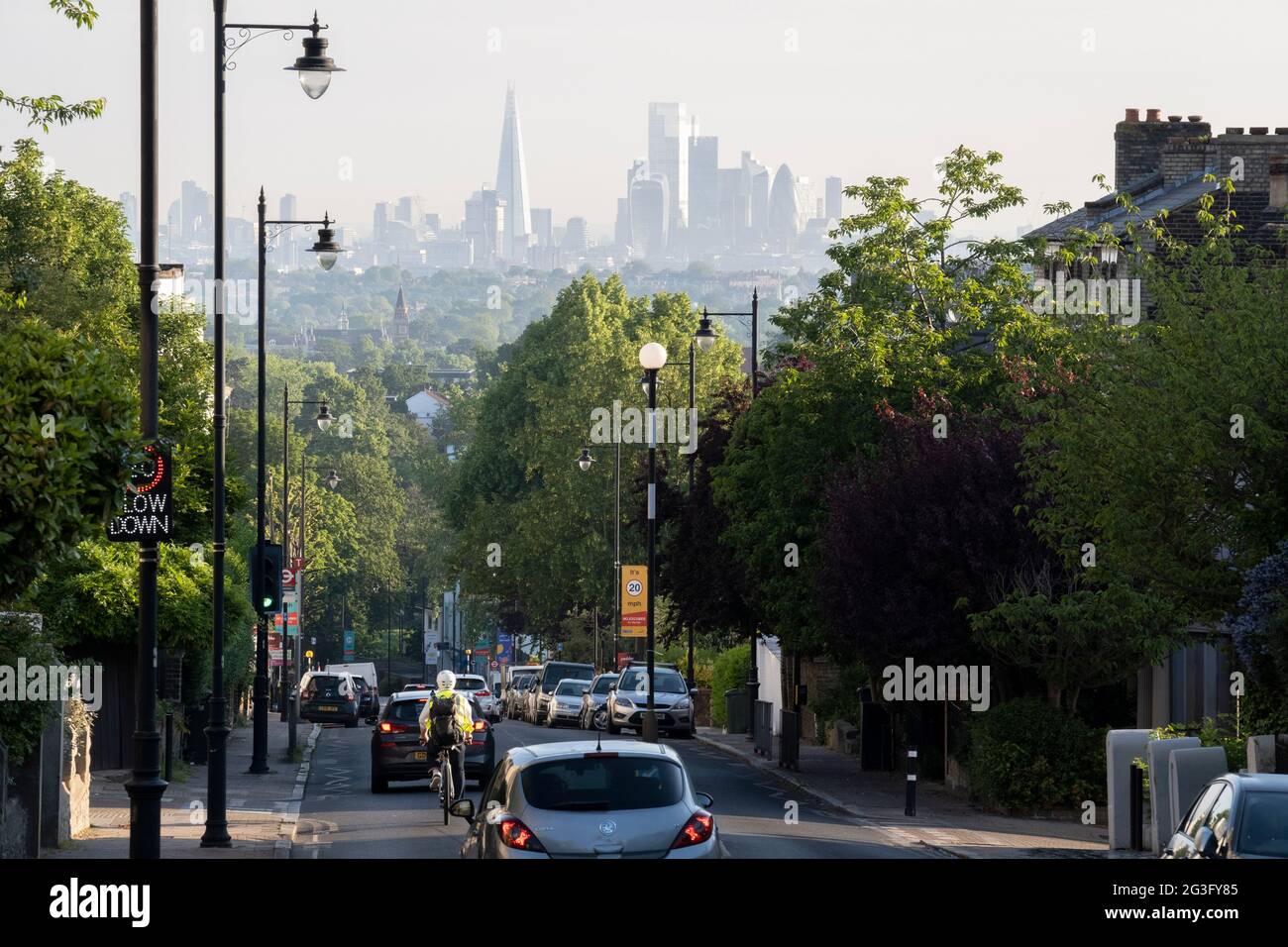 With the London skyline in the far distance, a cyclist and traffic ...