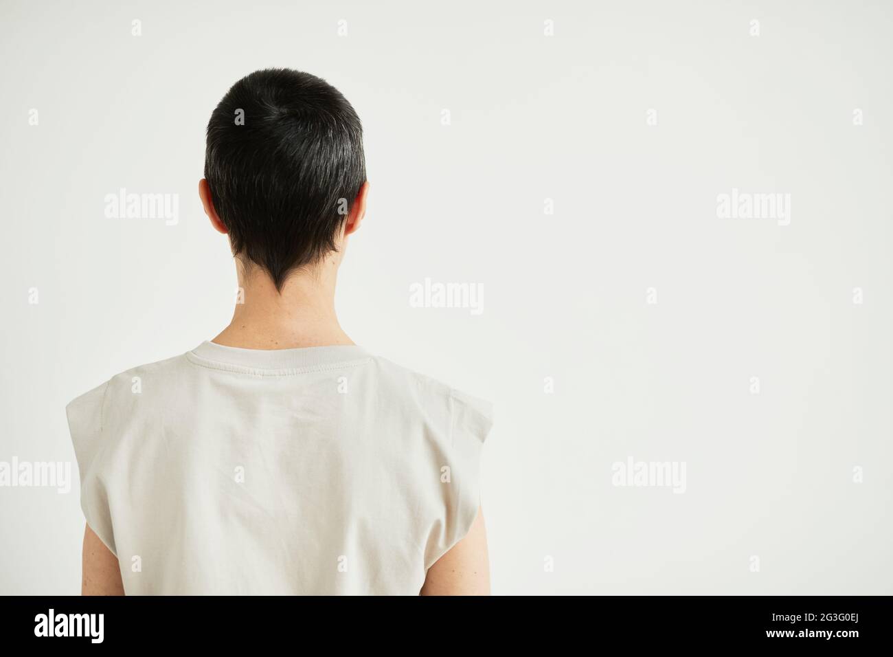 Minimal back view portrait of confident woman with short hair standing ...