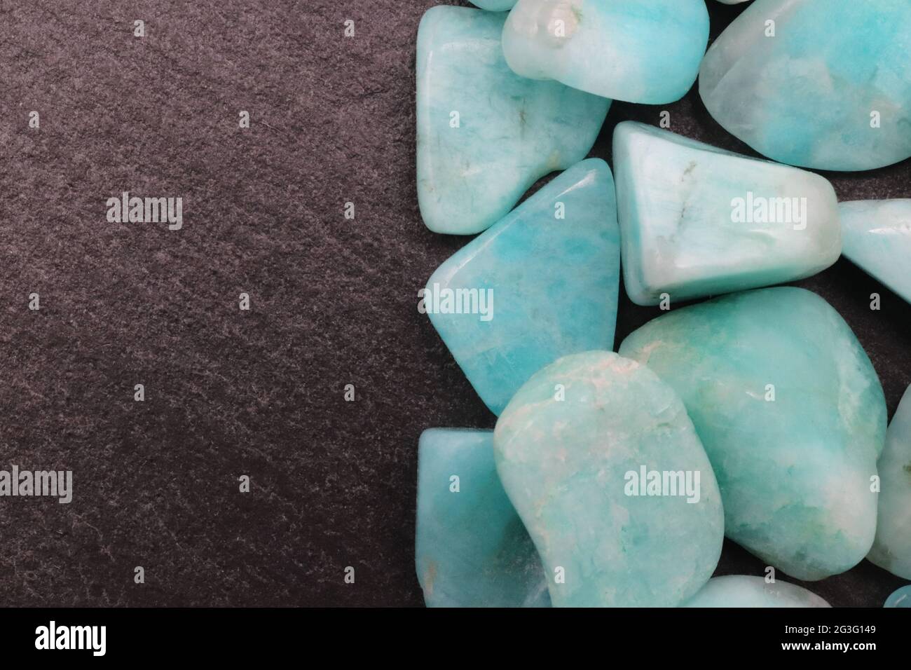 Amazonite jewel heap on black stone half background. Pile mineral ...