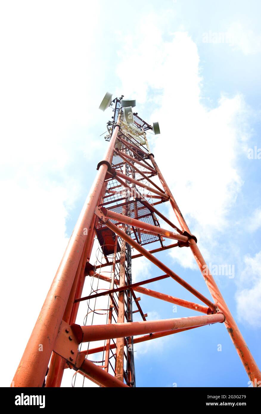 Telecommunication tower with antennas on a background of blue sky and clouds. Smart antennas ...
