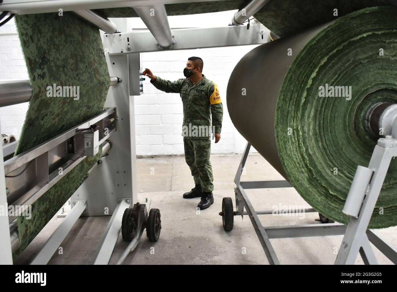 A military worker manufactures uniforms for members of Mexican Army at ...