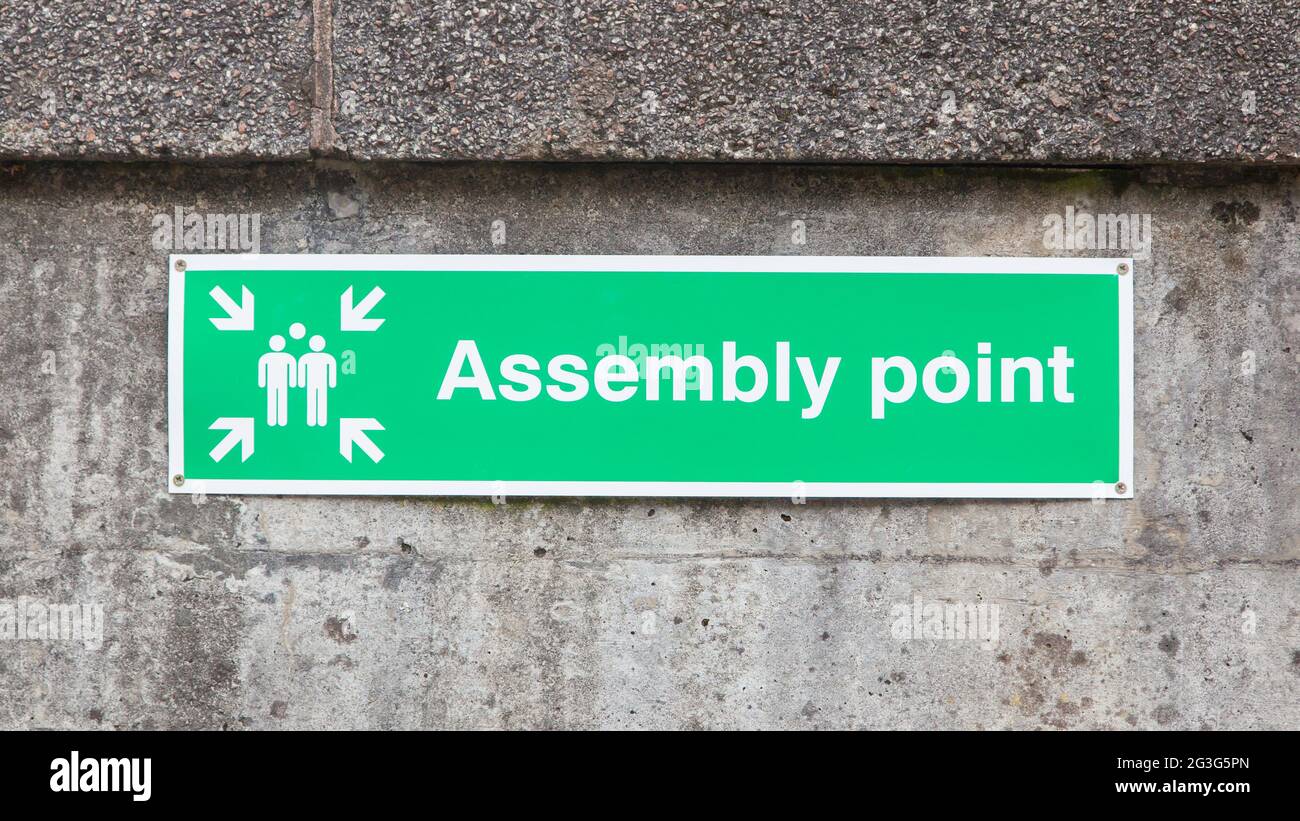 Green plastic 'assembly point' sign Stock Photo - Alamy