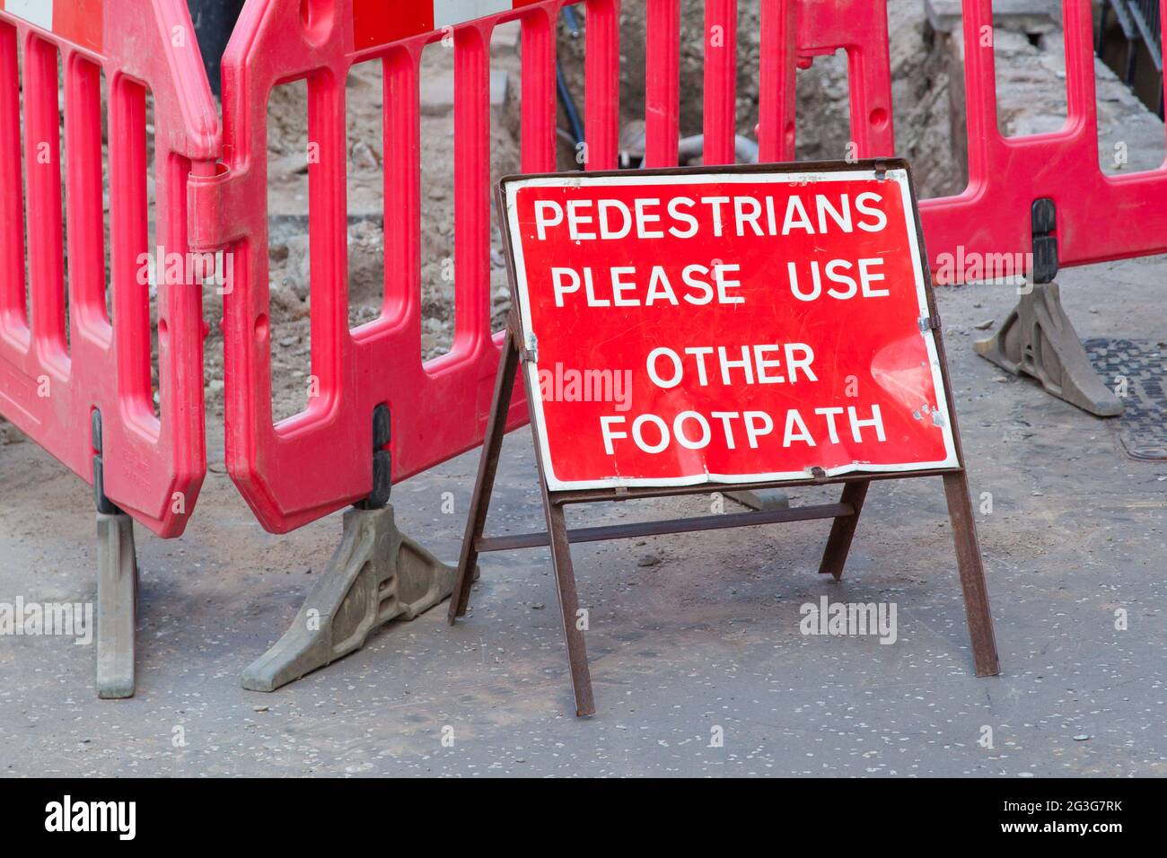 Construction sign standing on footpath Stock Photo - Alamy