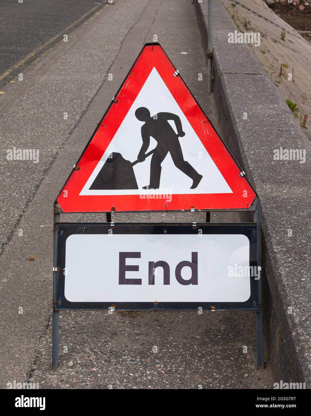 Triangular construction sign standing on footpath Stock Photo - Alamy