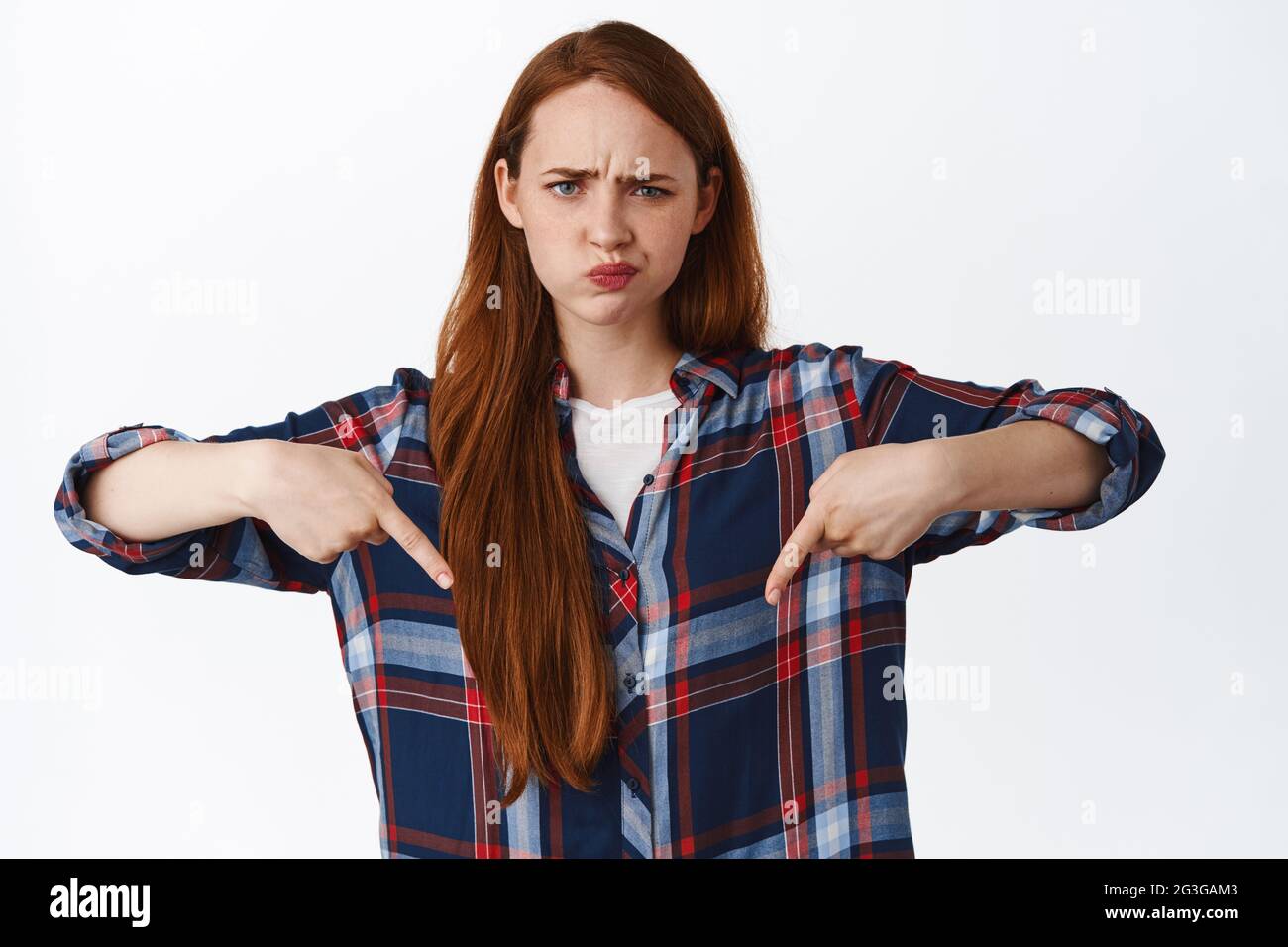 Skeptical and disappointed redhead girl, grimace, look with disbelief ...