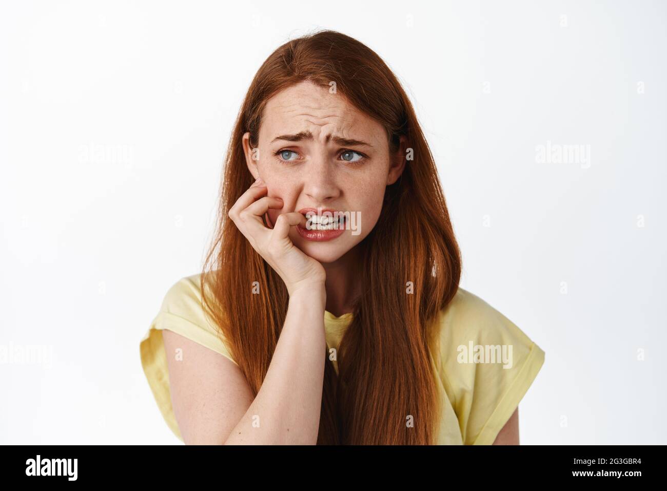 Close up of scared and insecure redhead teenage girl, biting fingers ...