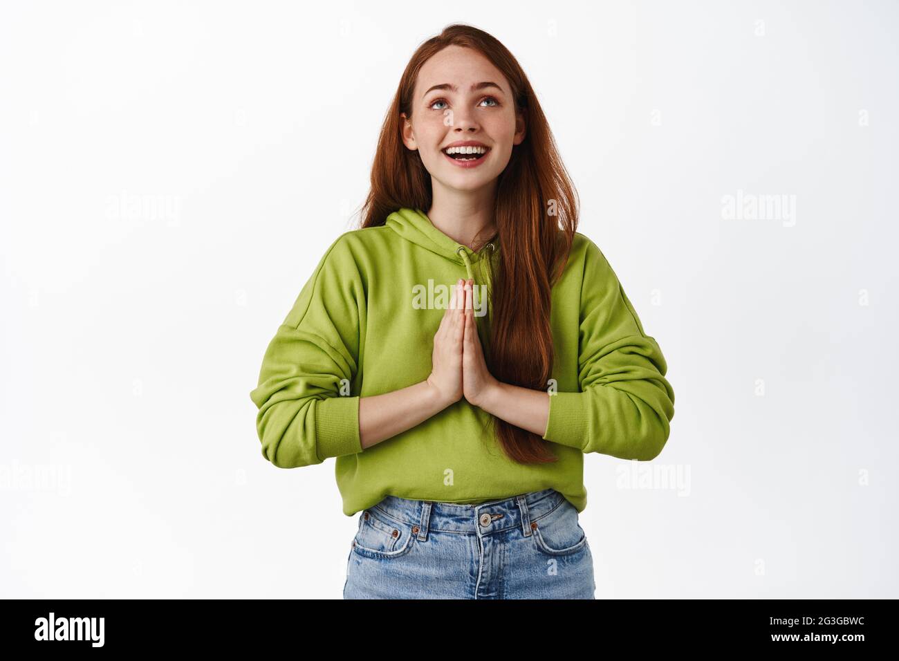 Image of smiling hopeful girl makes wish, holding hands in pray ...