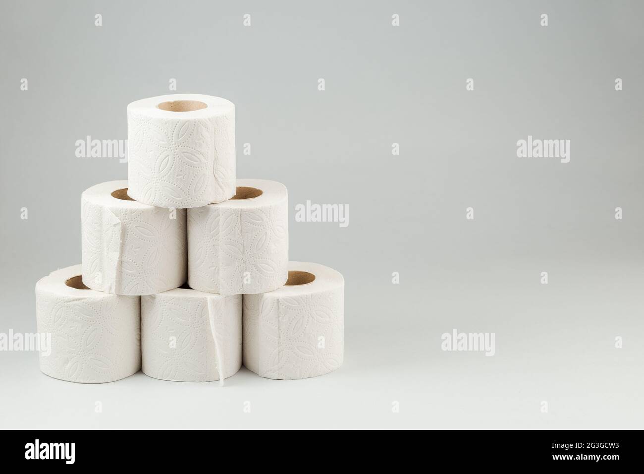 A Pyramid of Toilet Paper Rolls over Gray Background. Copy Space for ...