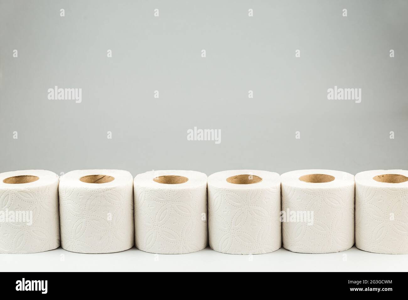 A Row of Toilet Paper Rolls over Gray Background with Copy Space for ...