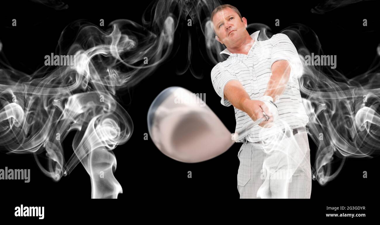 Caucasian male golf player swinging golf club against smoke effect on ...