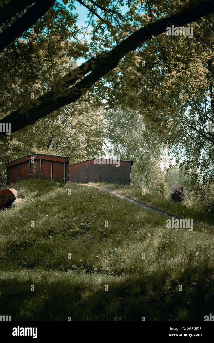Vertical shot of a park landscape with two big bins on the hill on a ...