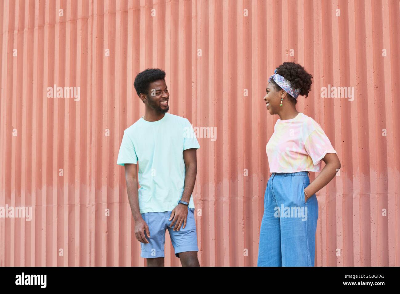 African young people talking to each other while standing outdoors ...