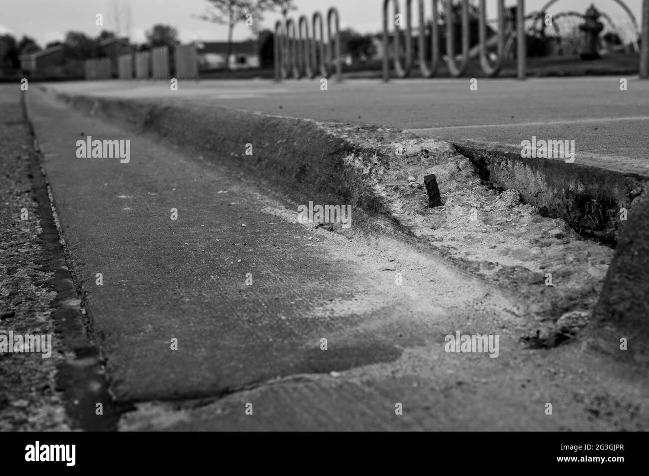 Broken sidewalk curb with exposed rebar and jagged edges that could ...