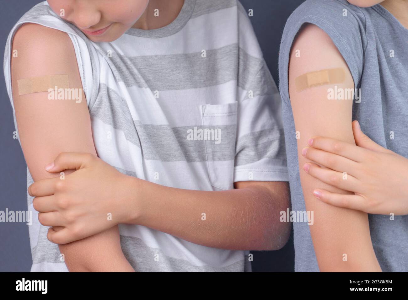 Teenage boys adhesive bandage plaster on their arms after vaccination ...