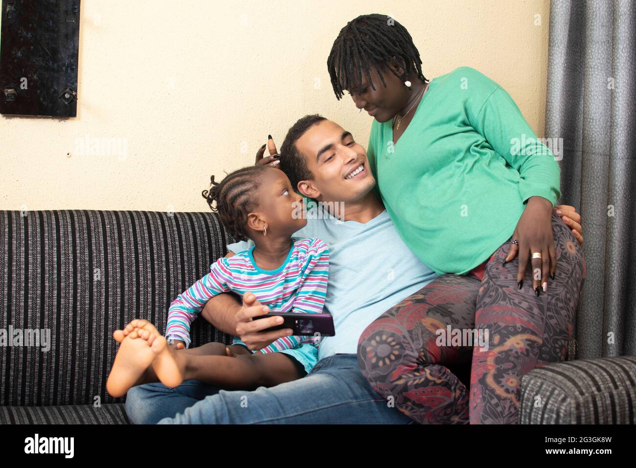 mixed race parents look at each other with a smile Stock Photo - Alamy