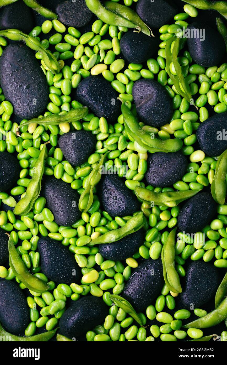 Green raw edamame soybeans and pods on black stone background. Flat lay ...
