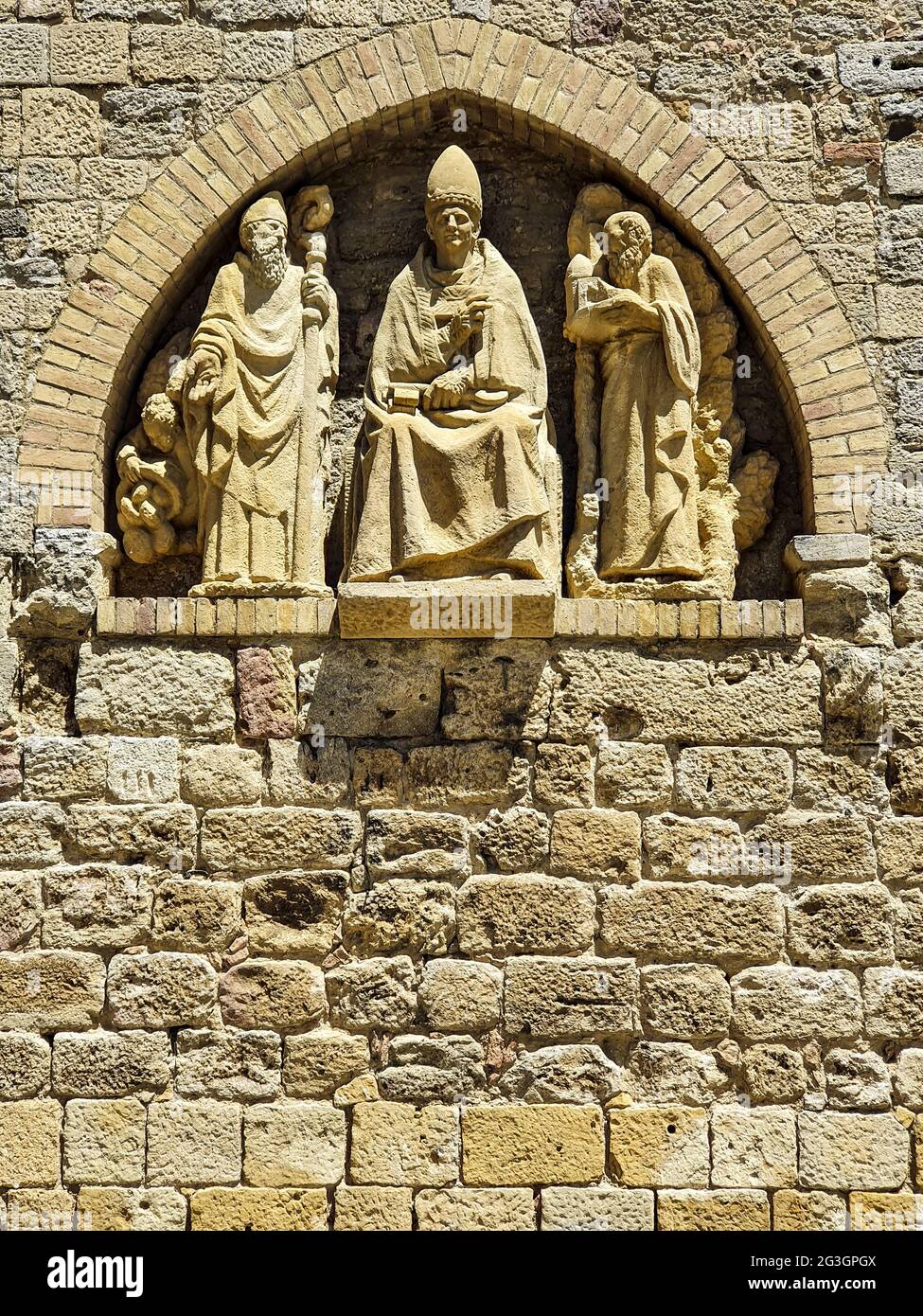 Vertical shot of a medieval statue on a stone wall building in Italy ...