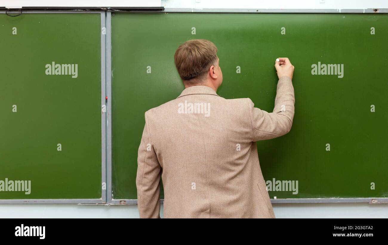 Math teacher writes chalk on blackboard copy space Stock Photo - Alamy