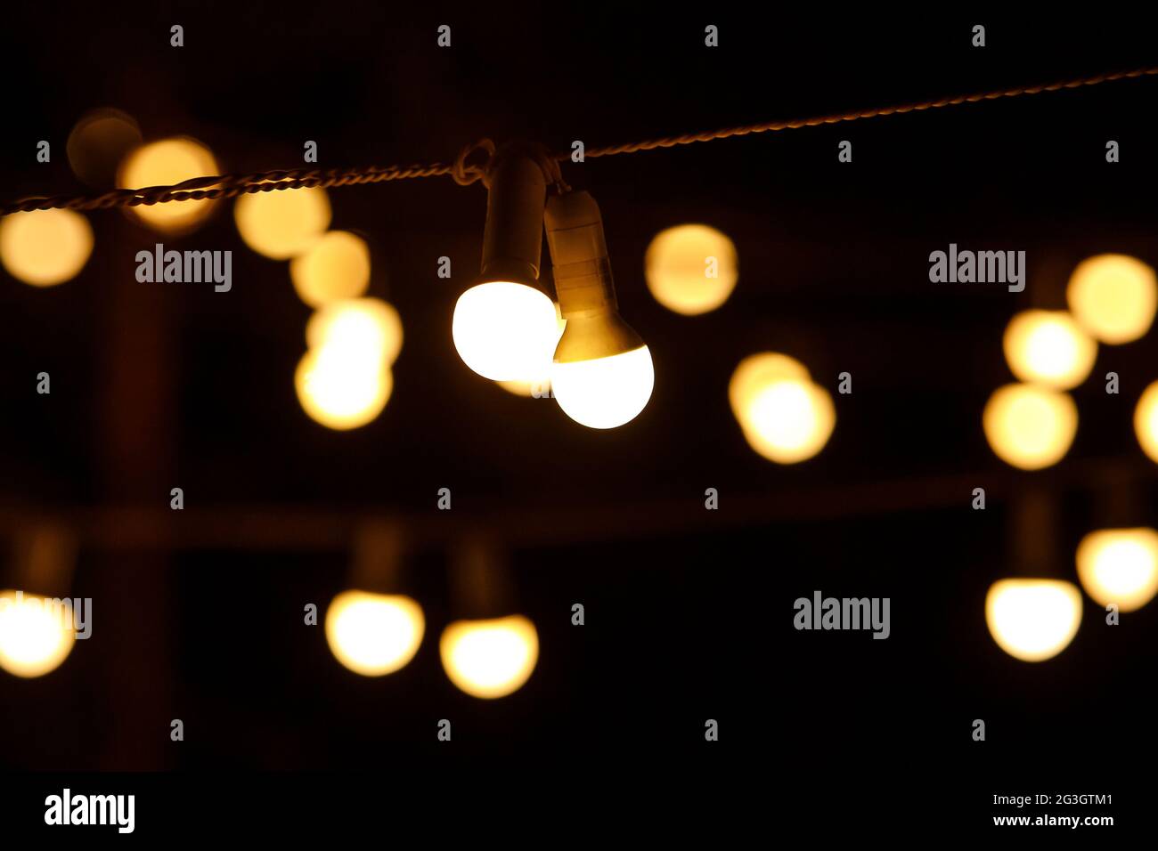 The chain of light bulbs at event Stock Photo - Alamy