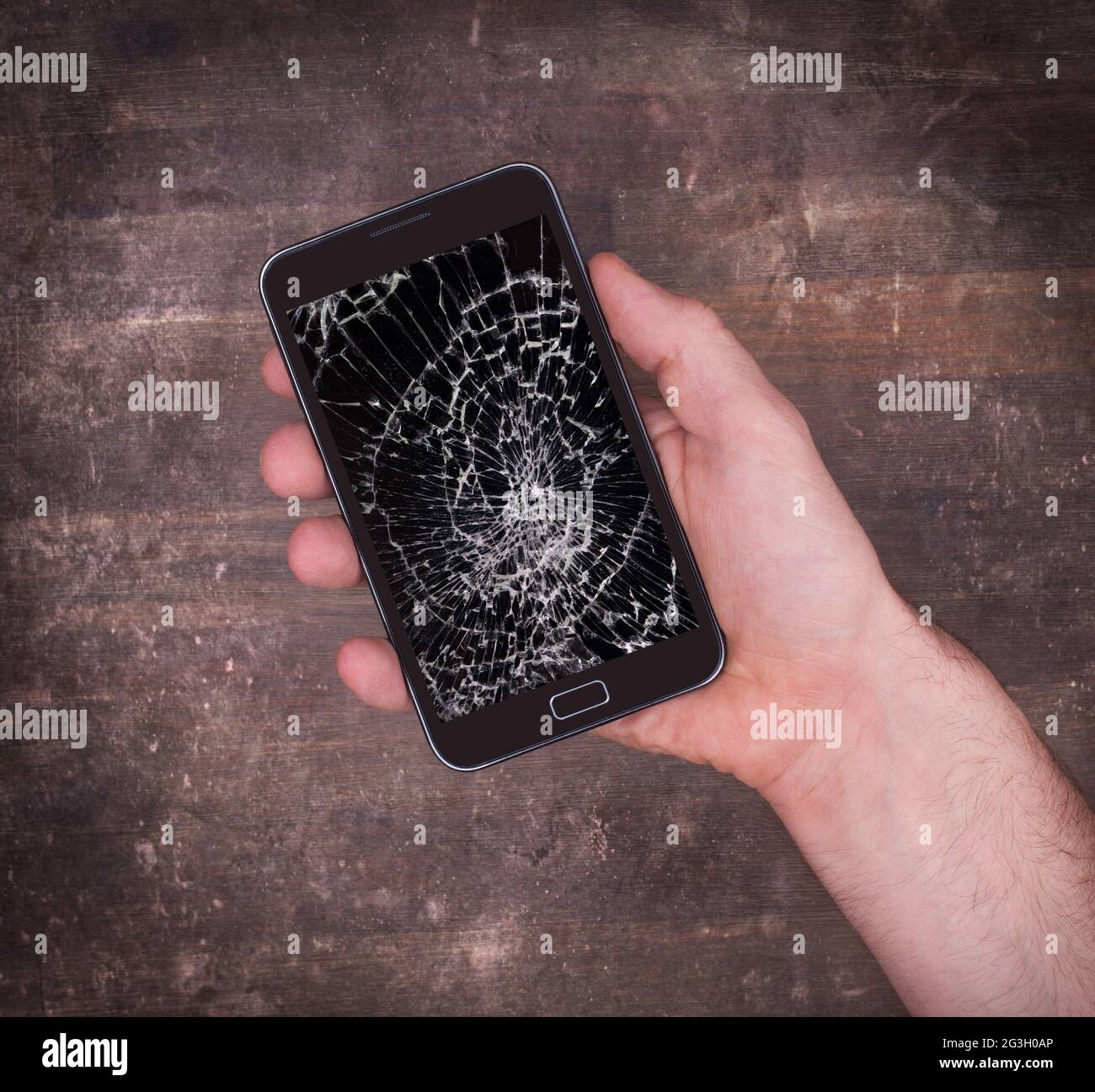 Hand holding a mobile phone with a broken screen Stock Photo - Alamy