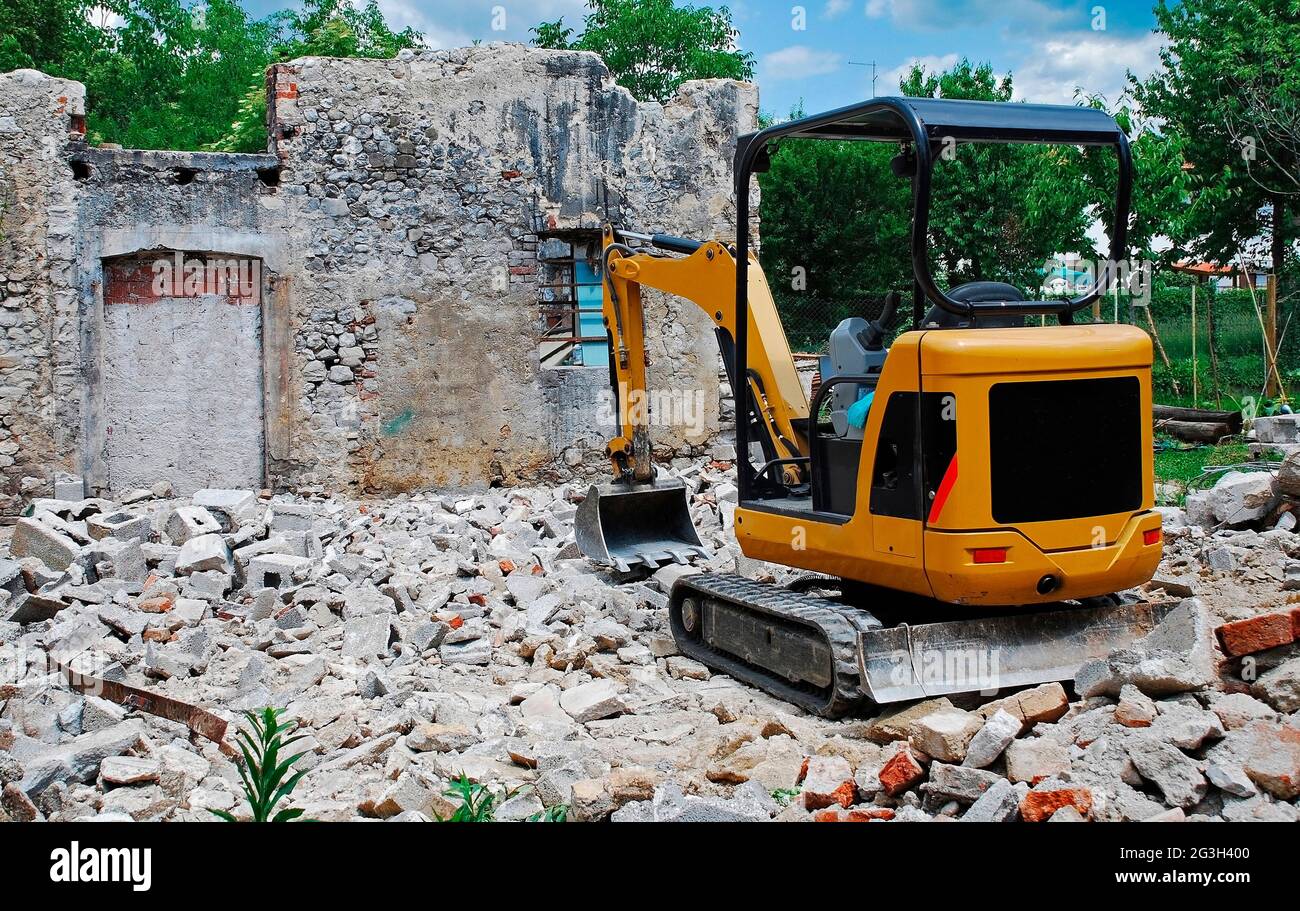 A compact excavator on a small domestic building site where a ...