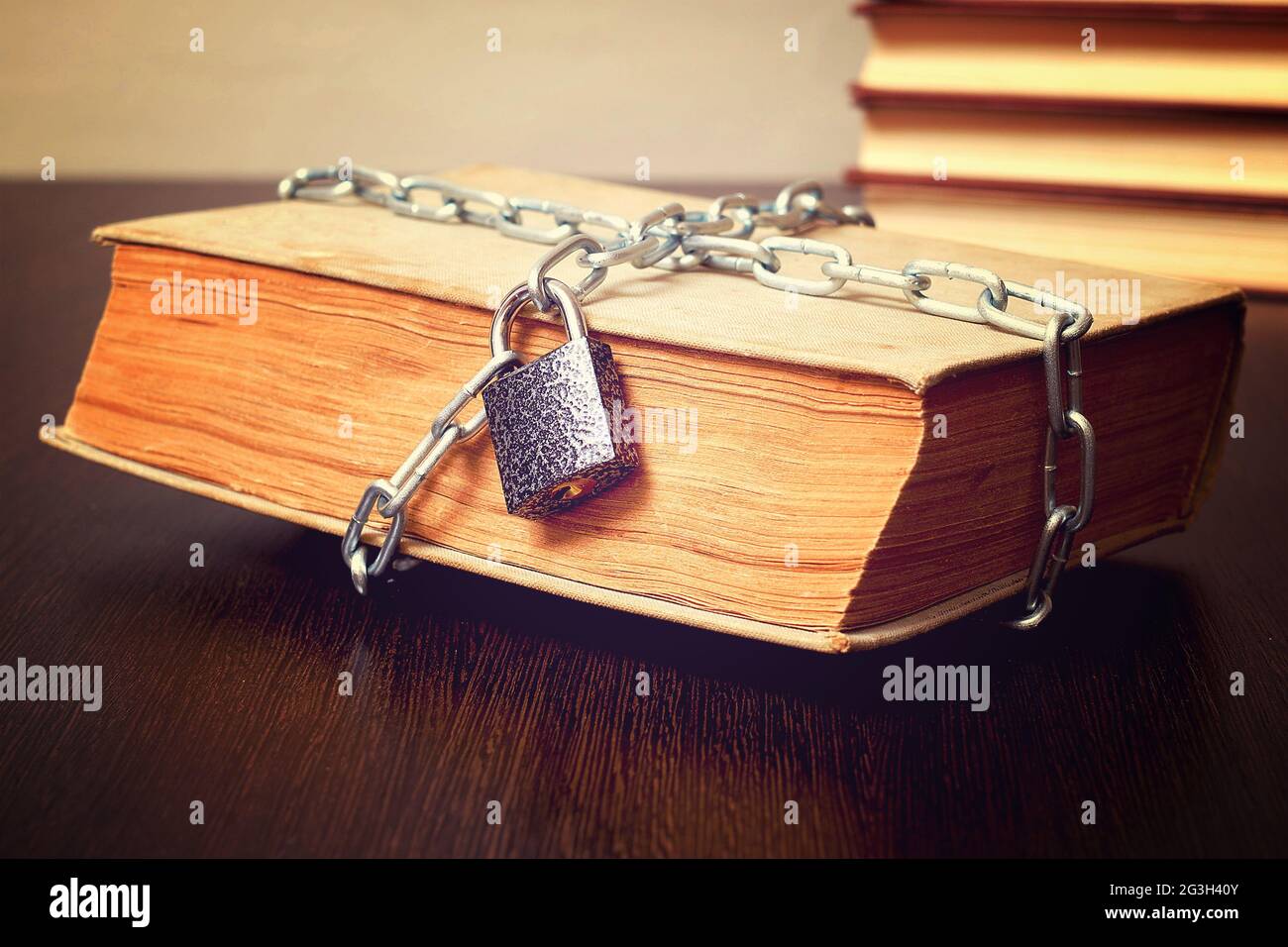 old book wrapped with chain and locked on padlock on table, concept ...