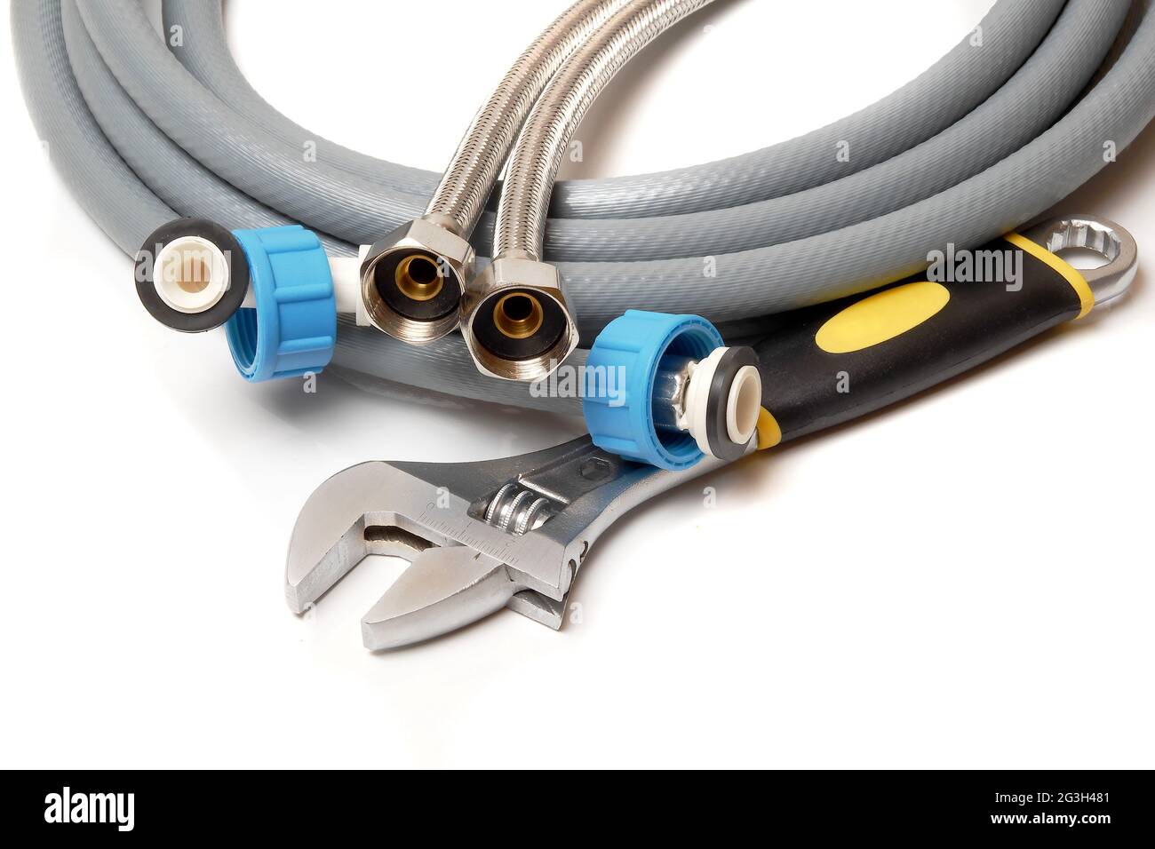 closeup on flexible water supply tubes and adjustable wrench on white ...