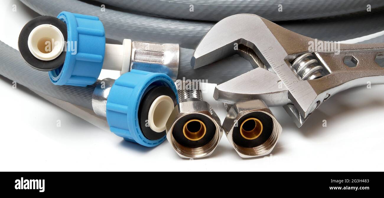 closeup on flexible water supply tubes and adjustable wrench on white ...