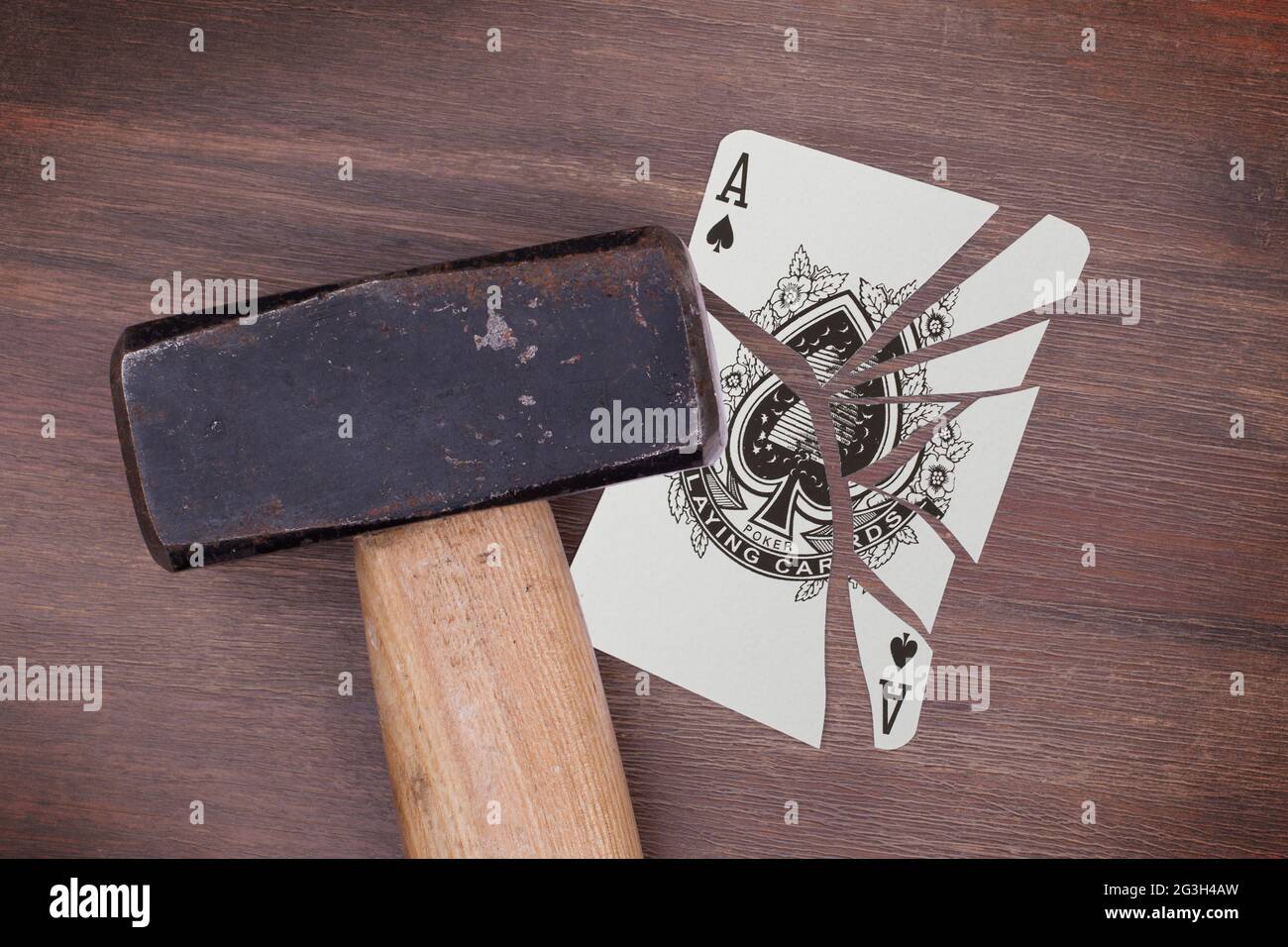 Hammer with a broken card, ace of spades Stock Photo - Alamy