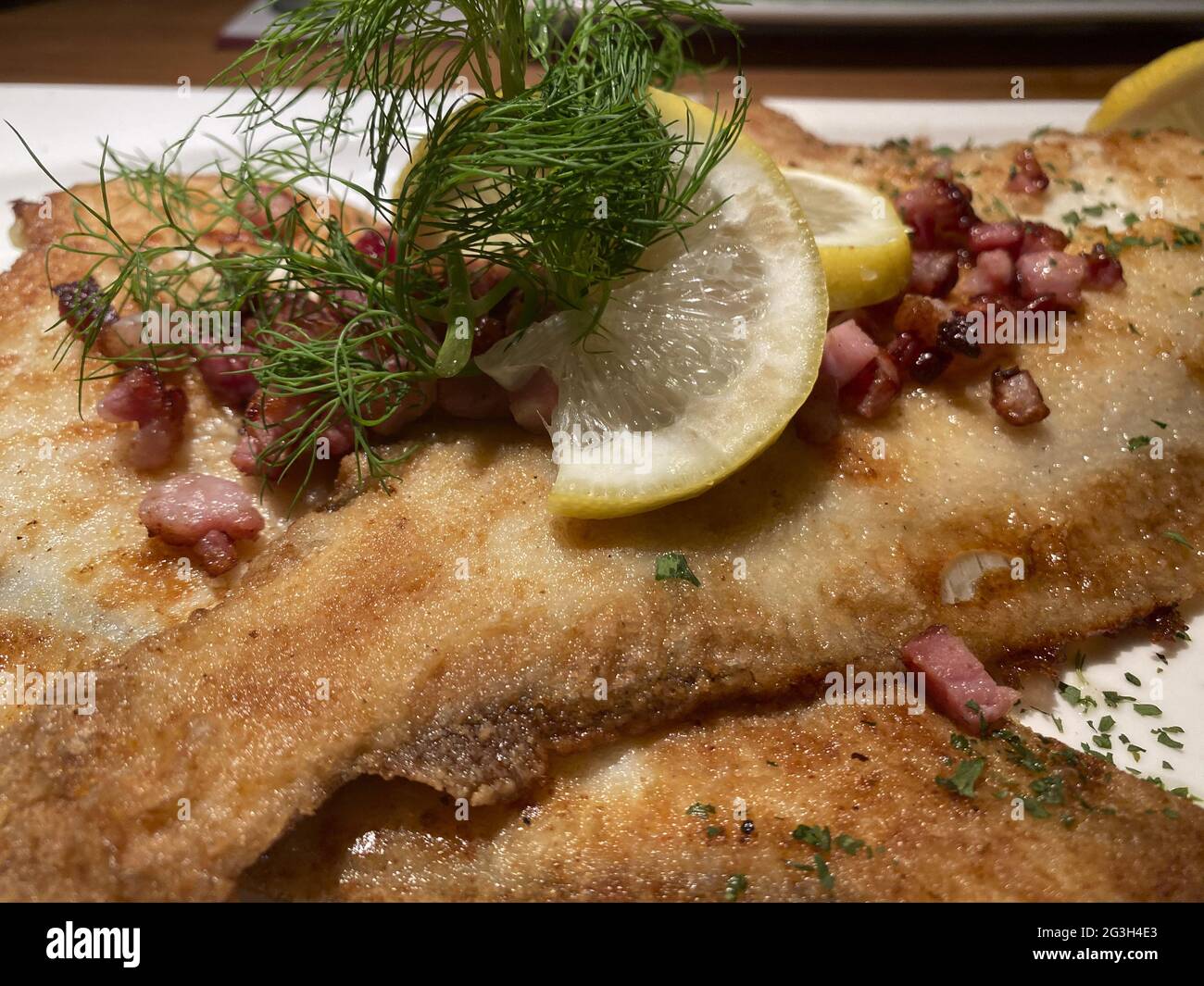 Fried and breaded plaice with bacon, lemon and dill.Plaice Finkenwerder ...
