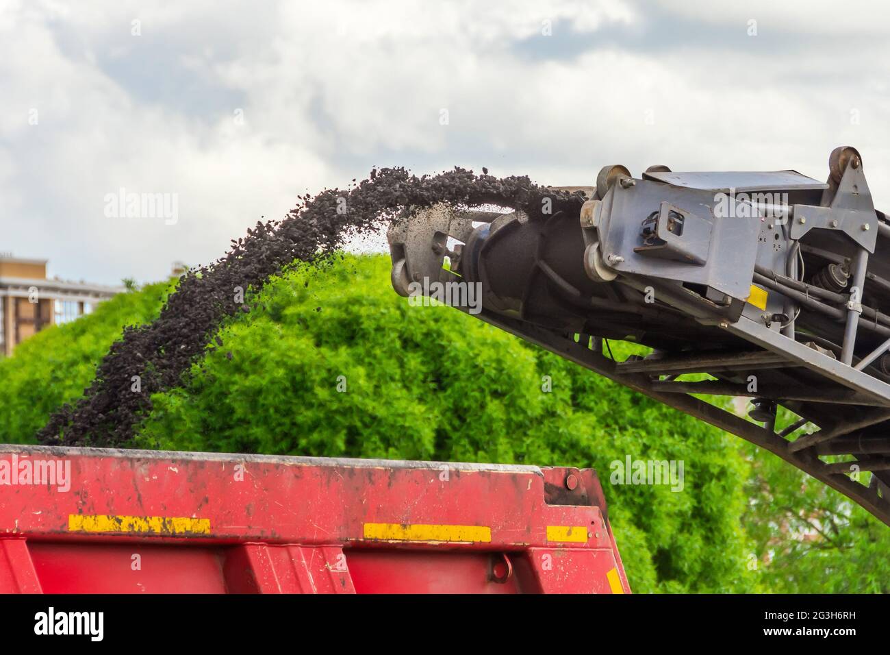 Road cold milling machine removes the old asphalt and loading into a ...