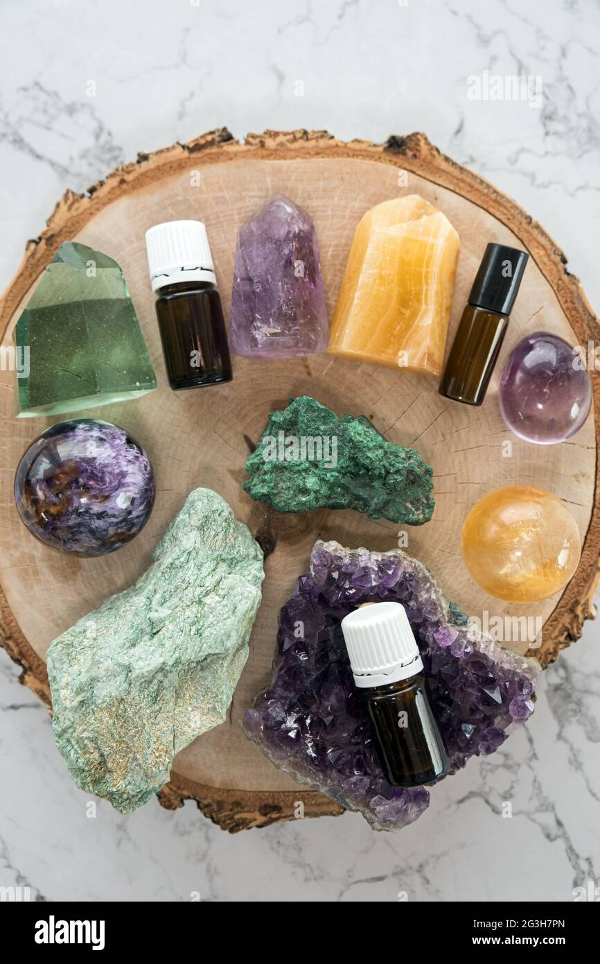 Closeup of essential oil bottles, colorful crystals and gemstones on ...