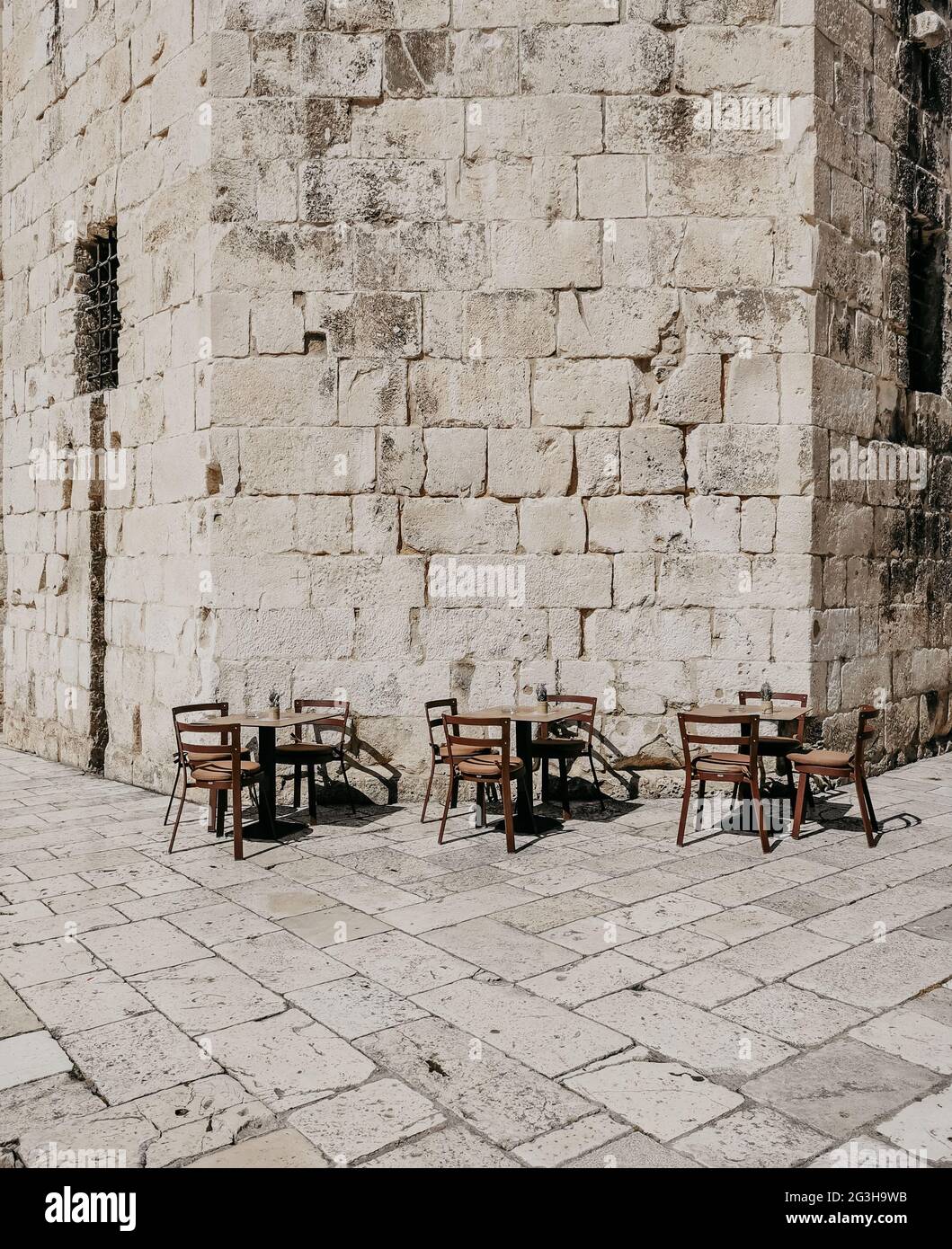 Empty tables and chairs on terrace of bar in historical district of ...