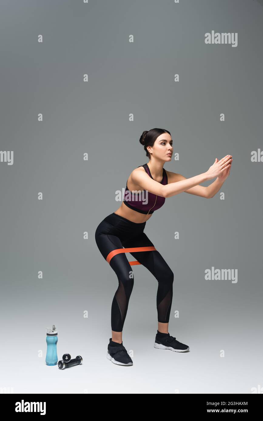 sportswoman doing sit ups with resistance band on grey background Stock ...