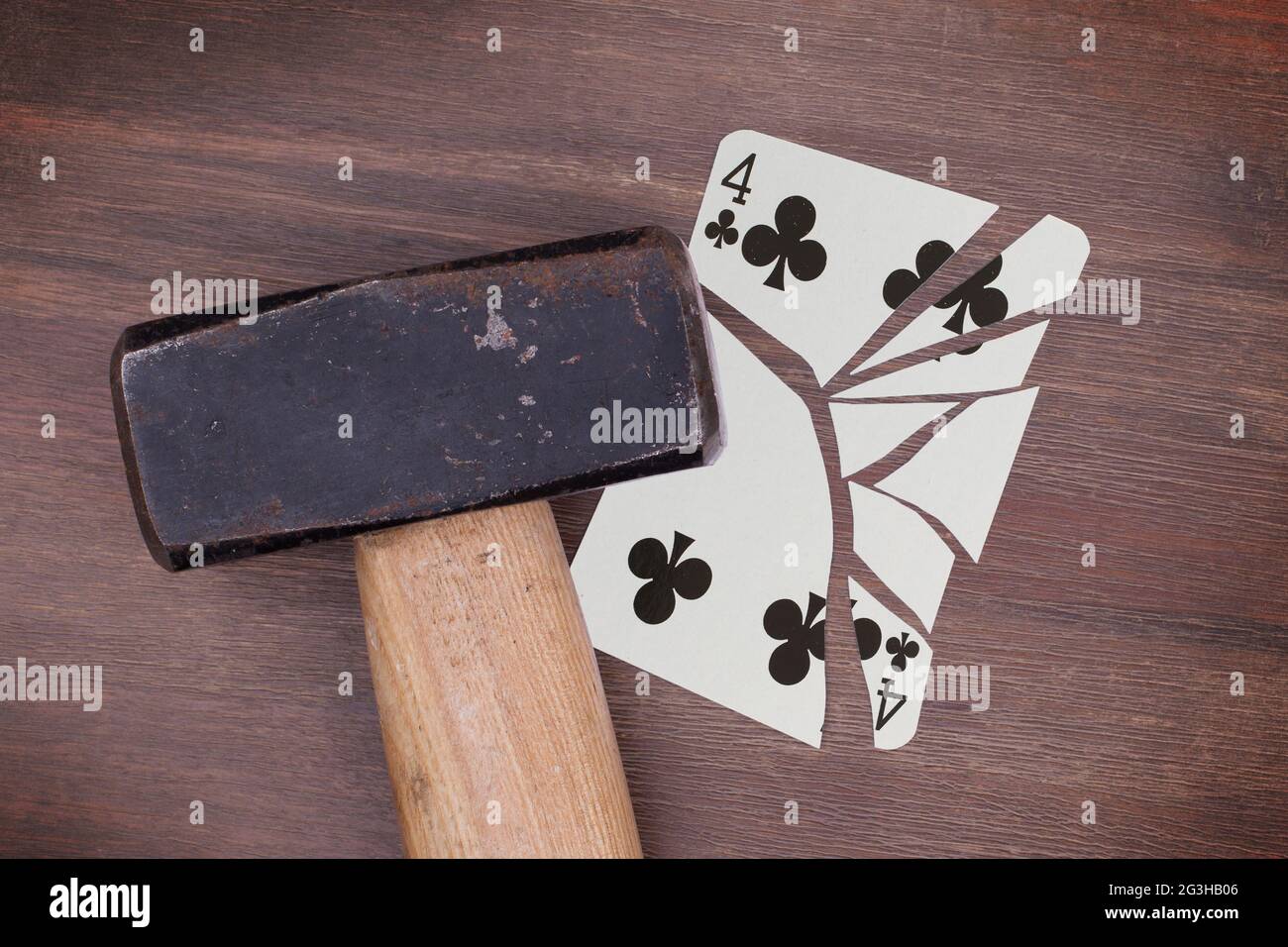 Hammer with a broken card, four of clubs Stock Photo - Alamy