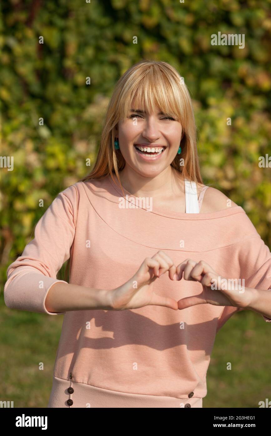 Beautiful girl show love sign Stock Photo - Alamy
